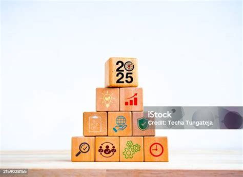 2025 새해 복 많이 받으세요 및 성공 경영 개념 2025 년 숫자 및 전략 계획 아이콘 나무 큐브 블록 피라미드 스택 나무 테이블과 흰색 배경에 고립 최소한의 스타일 0