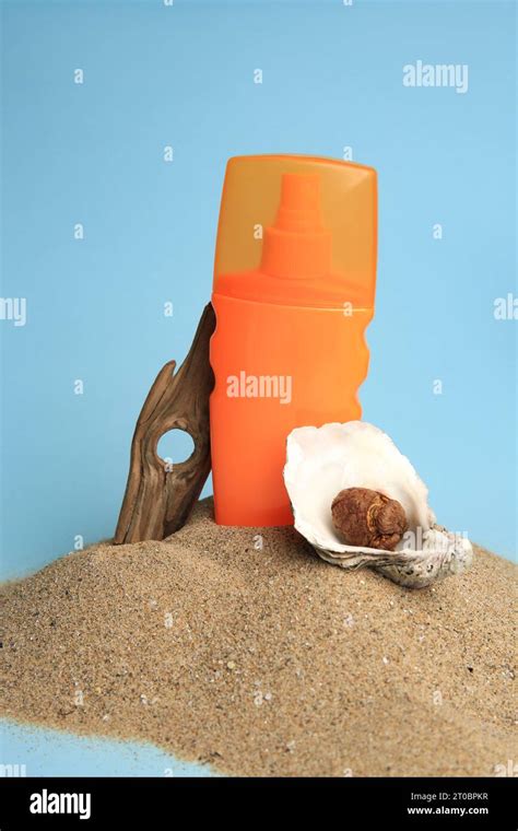 Sand With Bottle Of Sunscreen Tree Bark And Seashells Against Light