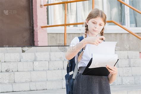 一个年轻，美丽，有吸引力和聪明的女学生的肖像，戴着眼镜，白色衬衫在一个户外演讲。她做演讲时面带微笑