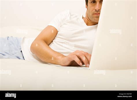 Man On Bed Using Laptop Computer Stock Photo Alamy