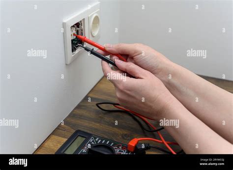 An Electrical Technician Measures Voltage Using A Multimeter Tester Measuring Voltage In A