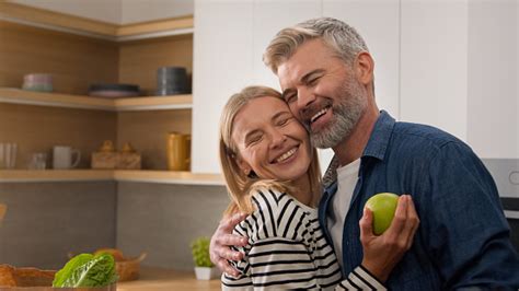 성인 행복 가족 커플 중년 남자 여자 포장 풀기 쇼핑백 구매 음식 배달 주문 아내 줘 사과 냄새 좋은 냄새 향기 킁킁 남편 포옹 포옹 부엌에서 상품 풀기 2명에 대한 스톡