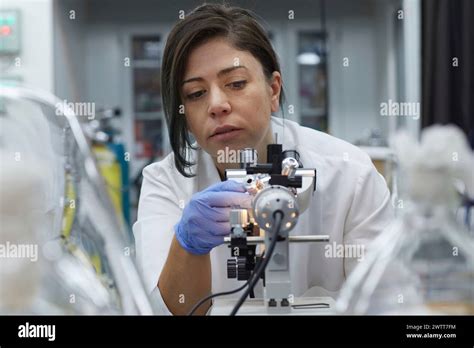 Attractive Female Scientist Testing Using Microscope To Test For Dna