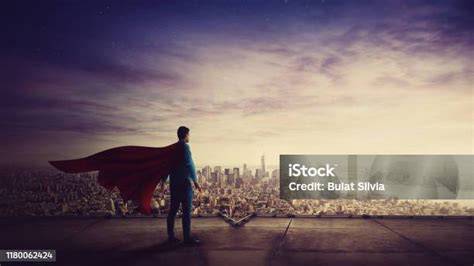 영웅이 도시의 지평선을 내려다 보는 고층 빌딩의 옥상에 서있는 것처럼 자신감있는 사업가 빨간 케이프 슈트 슈퍼 히어로 리더십과