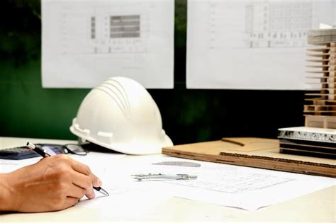 Premium Photo Cropped Hand Of Female Engineer Drawing Blueprint In Office