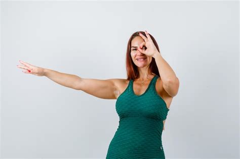 녹색 Bodycon을 입고 긴 머리를 가진 젊은 여자 무료 사진