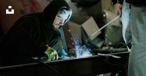 검은 까마귀를 입은 남자가 금속 조각을 작업하고 있다 사진 Unsplash의 무료 자동차 이미지