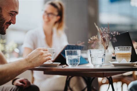 Startup Team In Business Meeting Brainstorming And Discussing Ideas In A Cafe Setting Stock