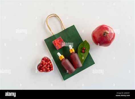 Red Dropper Bottles Of Pomegranate Serum Or Oil For Face And Body Lying On A White Table Stock
