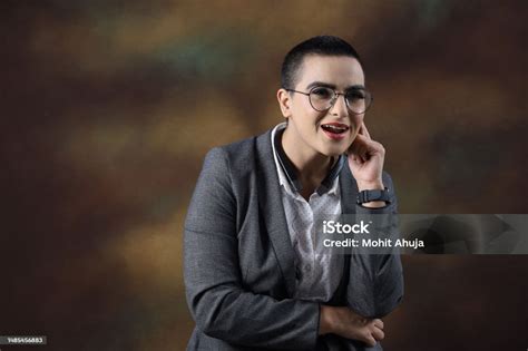 안경을 쓴 회사 정장을 입은 자신감 넘치는 젊은 여성 복사 공간이 있는 회색 배경에 고립된 웃고 있는 비즈니스 여성의 초상화 카메라를 보고 있는 스펙을 가진 자랑스러운