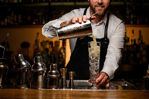 바텐더는 셰이커에서 맛있는 칵테일을 얼음 조각이있는 투명한 높은 유리에 붓습니다 강철에 대한 스톡 사진 및 기타 이미지 강철 결정체 구도 Istock