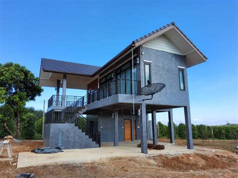 บ้านสองชั้นใต้ถุนสูงปล่อยโล่ง หลังคาจั่ว ผนังปูนลอฟท์ทันสมัย ไอเดียสร้างบ้าน