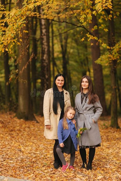 Maman Et Deux Filles S Amusent Dans Leur Parc La Fille La Plus Jeune Ramasse Les Feuilles Et Le