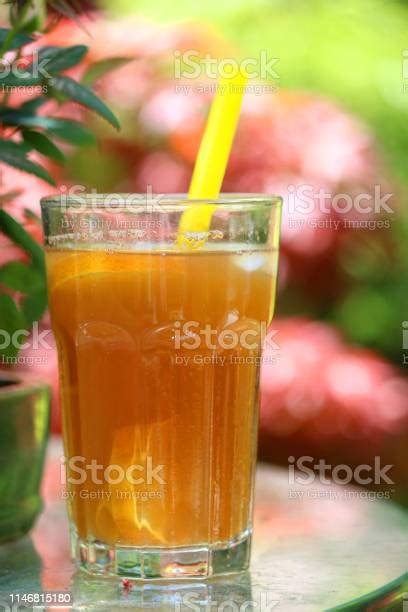 집에서 만든 롱 아일랜드 아이스 티 드링크와 보드카를 사용한 알콜 성 가든 칵테일 외부 파티오 테이블에 미니 레드 장미 꽃 레몬과 얼음 조각으로 미국 식당 유리에 노란색