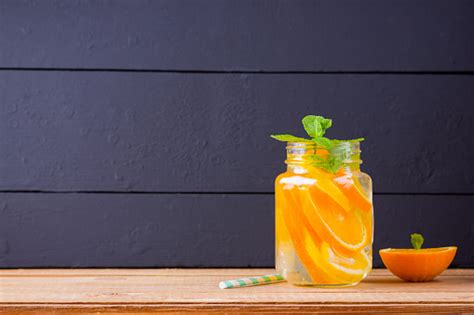 오렌지 레몬 민트가 함유 된 물 머그잔 나무 보드에 민트와 혼합 과일의 맛 있는 상쾌한 음료 메이슨 항아리에 아이스 여름 음료 홈메이드 디 톡 스 칵테일 0명에 대한 스톡