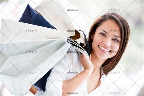 عکس با کیفیت خانم با لبخند و کیسه های خرید در دست عکس با کیفیت و تصاویر استوک حرفه ای