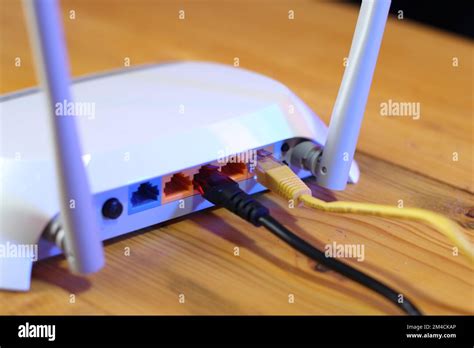 Back Of Router With Ethernet Ports And Connected Cables On Wooden Table
