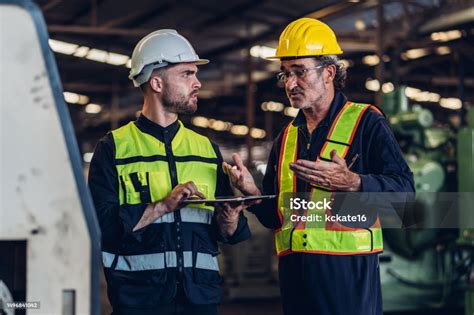 공장 현장에서 일하는 노동자 공장 또는 엔지니어링 현장의 기계 또는 제품을 확인합니다 감독 또는 기술자가 공장의 자재 또는 기계를 검사합니다 중공업 공장 개념입니다 2명에