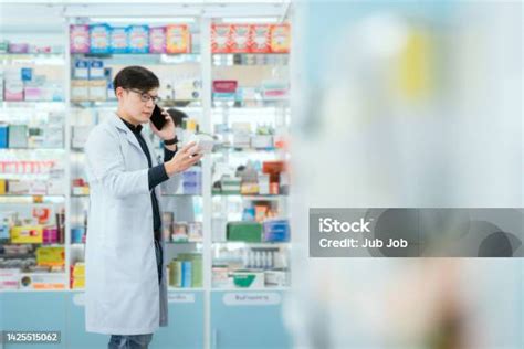 남성 약사는 지역 약국에서 의약품 재고를 확인합니다 전화를 사용하여 대화 약국에 대한 스톡 사진 및 기타 이미지 약국 약사
