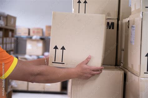 Close Up Hands Of Warehouse Worker Lifting Box In Storage Room Man Worker Working In Industrial