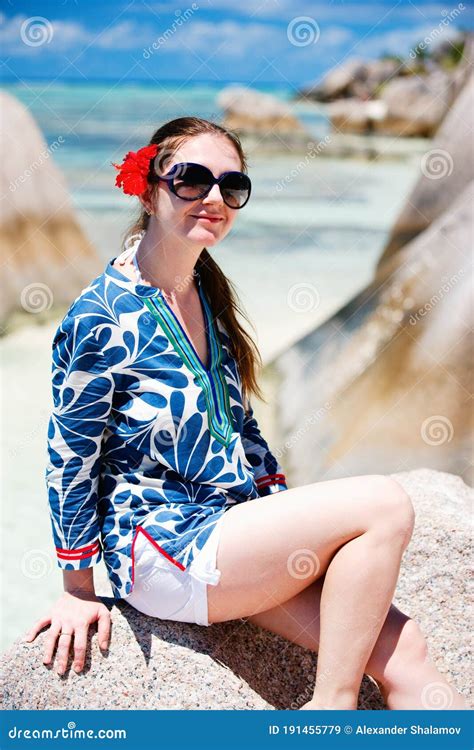 Женщина сидит на вершине скалы гранита Стоковое Изображение изображение насчитывающей вода