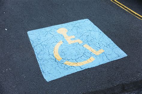 포용성 장애인 권리 및 접근 가능한 공간을 상징하는 흐릿한 배경에 휠체어 접근 가능 장애인 표지판 0명에 대한 스톡 사진 및