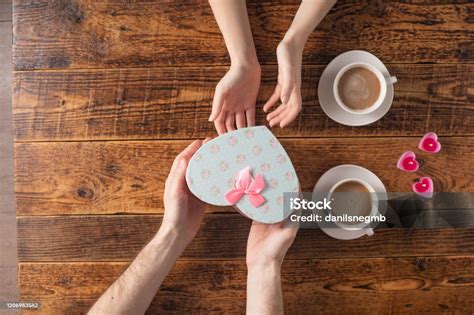 발렌타인 데이 축하 개념입니다 사랑하는 사람을위한 좋은 선물 나무 테이블 배경에 커피 잔과 남자와 여자의 손 공간을 복사합니다 플랫 레이 클로즈업 2명에 대한 스톡 사진 및