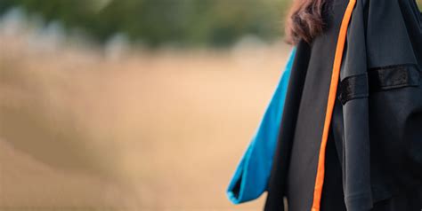 전통적인 가운 옷과 모자를 쓰고 일몰을 손에 들고 기장 졸업장을 들고 서 있는 졸업생 컨셉 교육 축하 졸업식 대학의 졸업생을 축하했다 25 29세에 대한 스톡 사진 및 기타