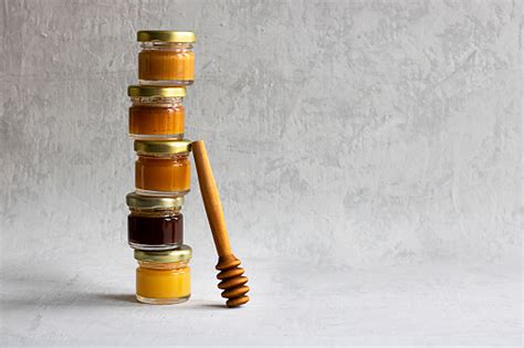 서로 다른 종류와 다른 꿀의 색상과 숟가락 분리 및 복사 공간 회색 시멘트 배경에 금속 캡 다섯 작은 유리 항아리 건강 한 제품 자연 수평 가득 찬에 대한 스톡 사진 및
