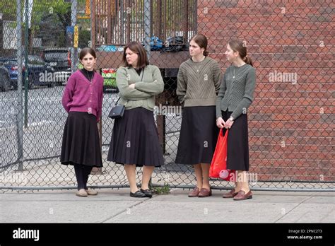 Modestly Dressed Orthodox Jewish Women Waiting On A Bus Stop In New
