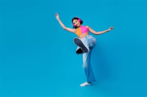 밝은 파란색 배경에서 활기찬 스타일과 에너지로 춤을 추는 헤드폰을 착용 한 쾌활한 젊은 여자 20 24세에 대한 스톡 사진 및 기타 이미지 Istock