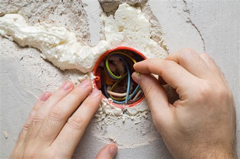 젊은 성인 남자 손가락 와이어를 들고 콘크리트 벽에 플라스틱 콘센트를 설치 근접 촬영 가정의 수리 작업 리노베이션 프로세스 관점 샷 Diy에 대한 스톡 사진 및 기타 이미지
