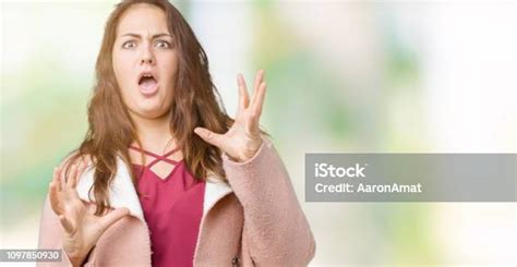 플러스 크기 젊은 여 자가 아름 다운에 겨울 코트를 입고 배경 미친 절연 고 미친 소리 하 고 적극적인 식와 팔 발생 함 좌절 개념입니다 갈색 머리에 대한 스톡 사진 및