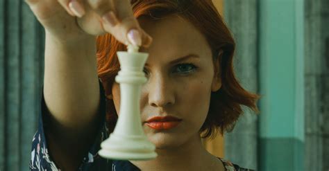 Redhead Woman Holding Out White Chess Piece In Front Of Her · Free