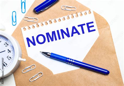 On A Light Background A Craft Envelope An Alarm Clock Paper Clips A Blue Pen And A Sheet Of