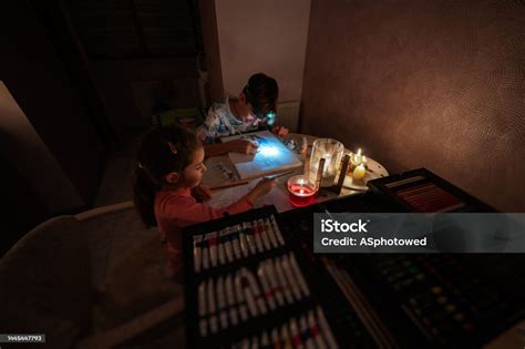유럽의 에너지 위기 동안 정전을 일으키는 동안 함께 시간을 보내는 가족 정전 상태에서 그림을 그리는 아이들 12 13세에 대한 스톡 사진 및 기타 이미지 Istock