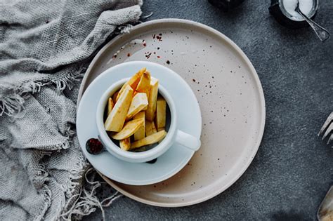 어두운 부엌 올리브 오일 거친 소금 고추와 T 배경에 파프리카도자기 머그잔에 원시 젓가락 고구마 슬라이스 빠른 수제 얌 조리법 국가 음식 선택적 초점 0명에 대한 스톡 사진