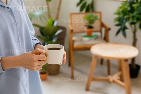 그린테리어화분이 많은 공간에서 커피 마시는 사람 사진 이미지 유토이미지 상세페이지 베이직샵 사진 22097946