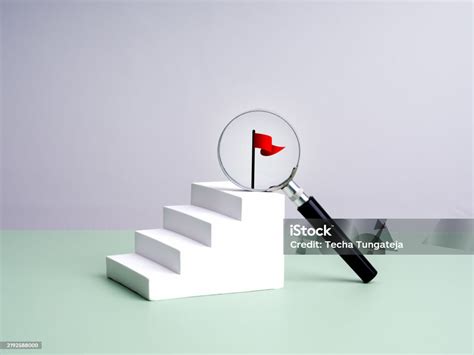 빨간 우승자 깃발은 녹색 테이블과 흰색 배경에 막대 그래프 차트 단계로 흰색 기하학적 계단 위에 돋보기로 초점을 맞췄습니다 비즈니스 성공 분석 목표 학습 개념 0명에 대한