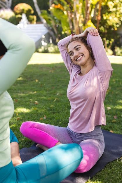 Premium Photo Happy Biracial Lesbian Couple Practicing Yoga Sitting Stretching In Sunny Garden