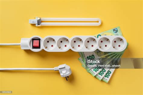 노란색 배경 위에 100 유로 지폐 전기 플러그 및 형광 전구에 전원 스트립 전력 위기로 인한 조명 난방 및 냉방 비용 증가 높은 에너지 비용과 인플레이션 0명에 대한 스톡