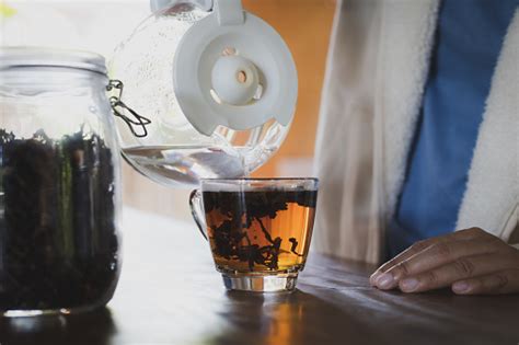 집에서 부엌에서 마른 차 잎컵 유리에 주전자에서 뜨거운 물을 붓는 여자 차 뜨거운 음료에 대한 스톡 사진 및 기타 이미지 차 뜨거운 음료 35 39세 가정 생활