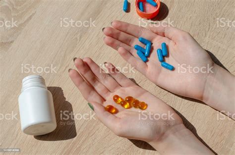 알약을위한 플라스틱 항아리 주황색 뚜껑이있는 흰색 항아리 감기약 제약 활성 환자는 약을 복용합니다 소녀는 질병에 대한 치료법이있는 여러 가지 색의 캡슐을 가지고 있습니다