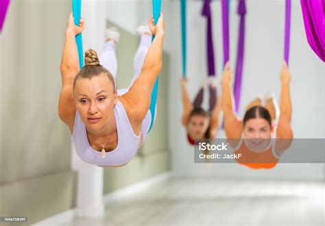 실크 해먹에 매달린 여성의 전체 길이 측면 보기 초상화 공중 요가를 연습하는 우아한 자세의 소녀 20 24세에 대한 스톡 사진 및 기타 이미지 Istock