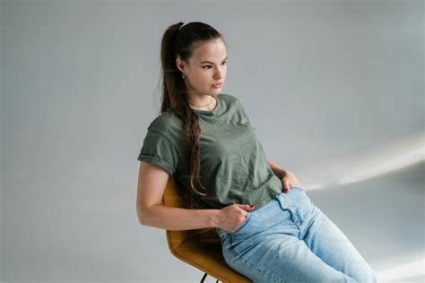 Una Mujer Sentada En Una Silla Con Las Piernas Cruzadas Foto Imagen De Estilo En Unsplash