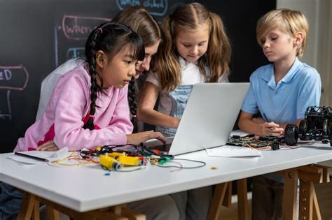 Premium Photo Girl Wear Pink Cloth Use Laptop For Coding While Teacher Watch Her Erudition