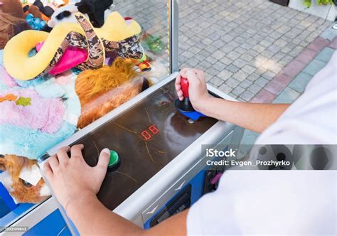 어린이의 손은 아케이드 크레인 자동 판매기의 빨간 조이스틱을 제어합니다 물건을 잡는 기계 장치에 대한 스톡 사진 및 기타 이미지 물건을 잡는 기계 장치 크레인 갈고리