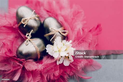 빨간색 수제 Dna4 종이 분홍색 깃털 둥지에 있는 어두운 금속 부활절 달걀 어두운 대리석 배경에 금속으로 칠해진 부활절 토끼와 황금빛 하트로 구성된 대조적인 모형 꽃