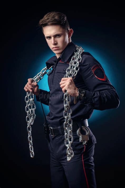 Handsome Guy In A Police Officer`s Uniform With A Gun English
