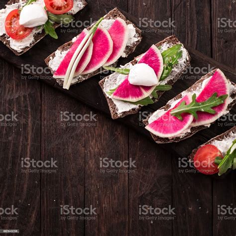 크림 치즈와 신선한 오이 무 토마토 Arugula 모 짜 렐 라와 샌드위치 Crispbread와 신선한 건강 한 전채 간식입니다